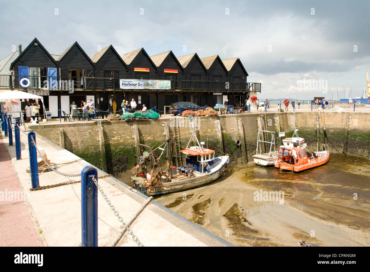 Boats at low tide in Whitstable Harbour and fish market in Kent ...