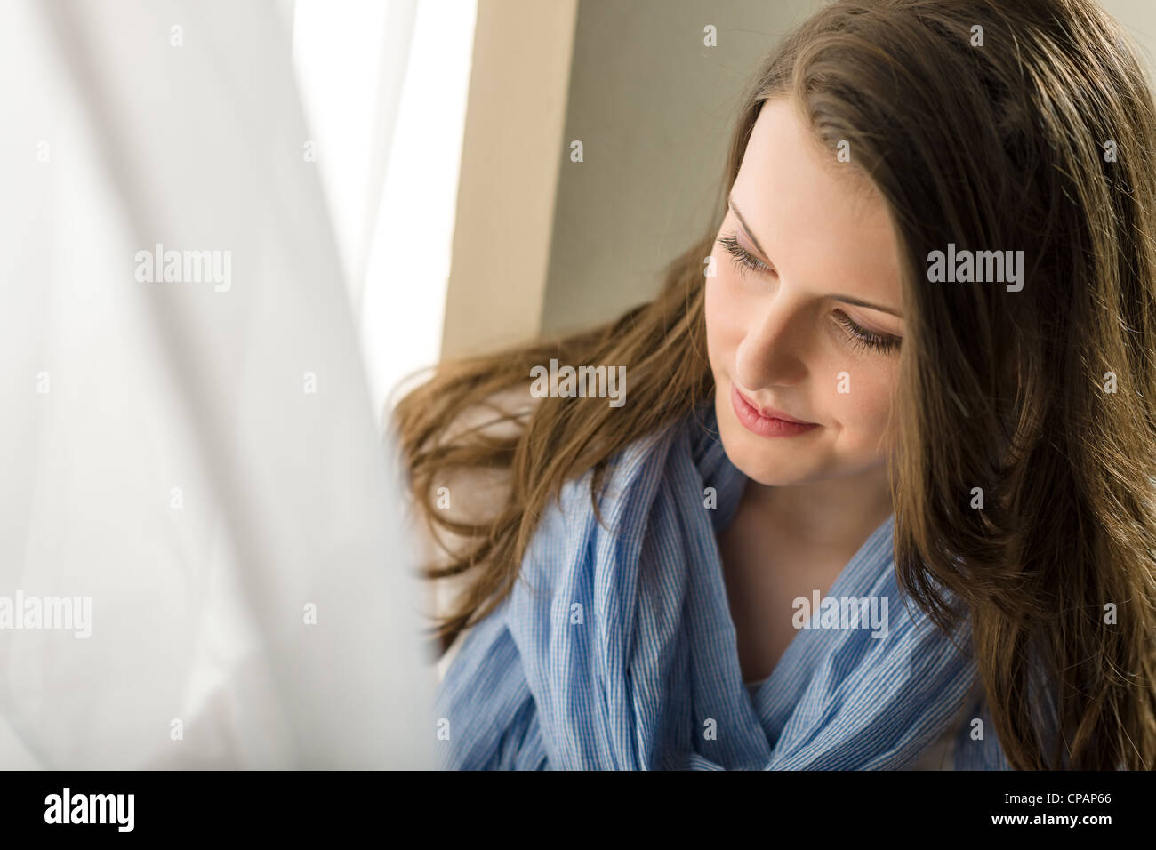 Young woman next to window looking down romantic pure portrait Stock ...