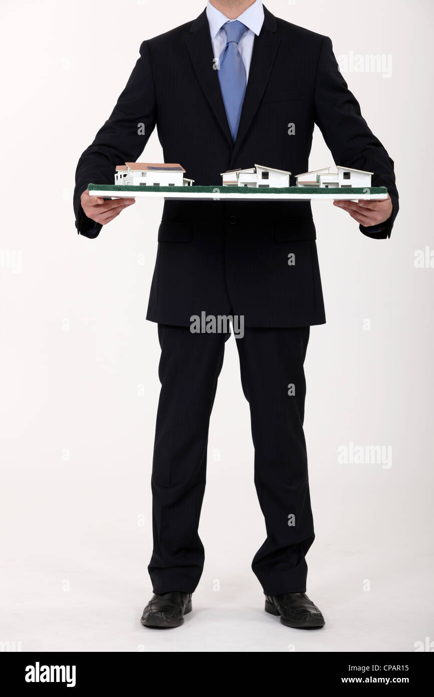 Businessman holding a model of a housing estate Stock Photo - Alamy