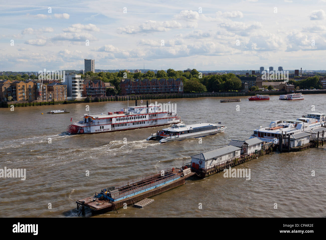 Pleasure boat and Thames Clipper pass Wapping on River Thames, London ...