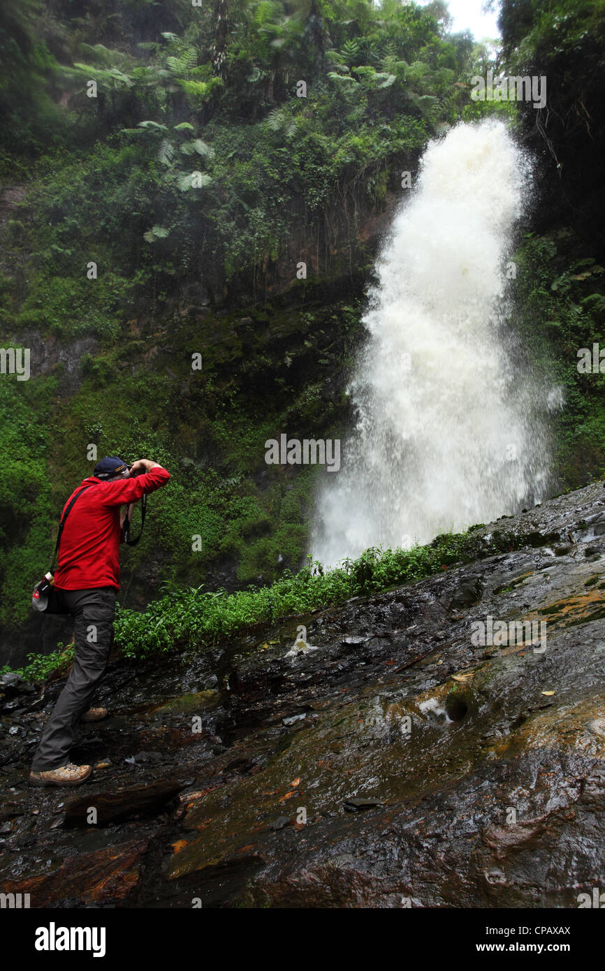 A man photographs Kamarinzovu Waterfall in Nyungwe National Park ...