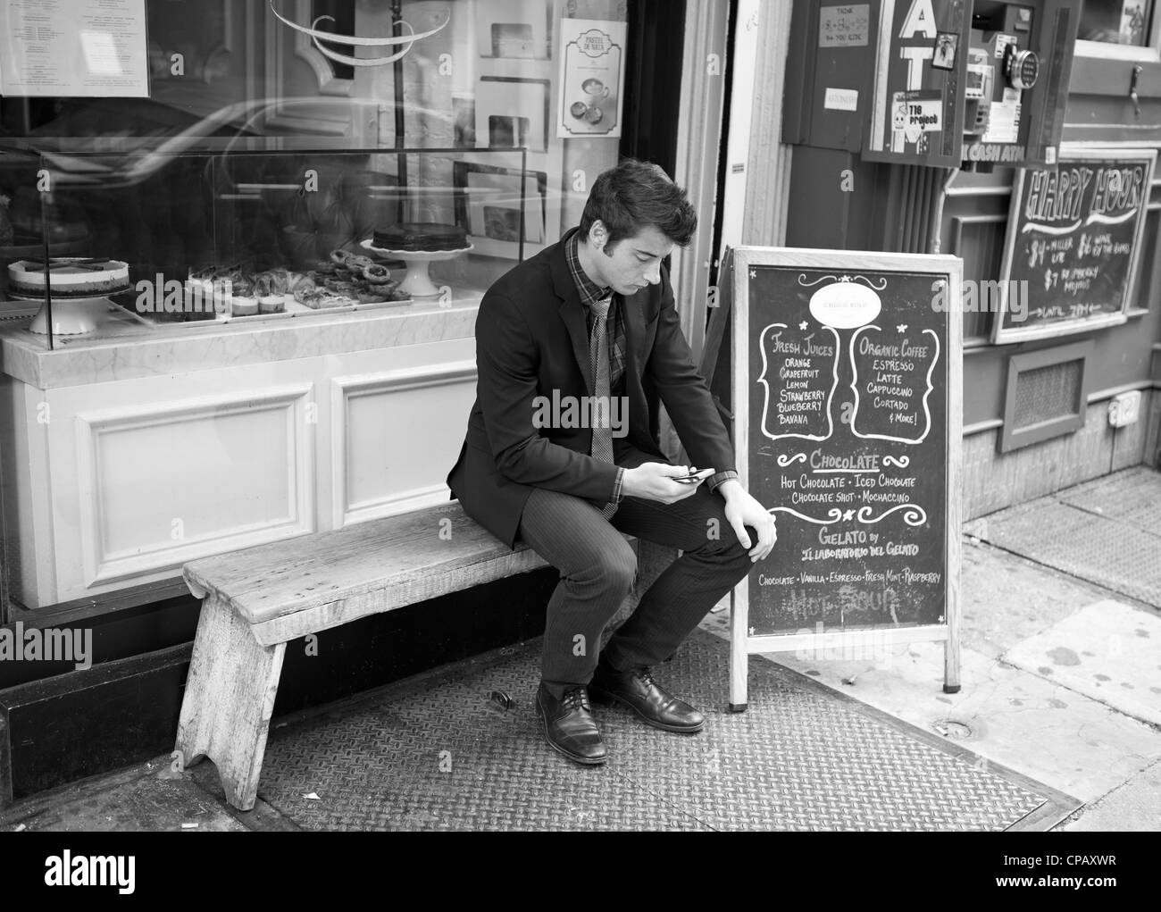 A man checks his phone while waiting outside a restaurant in New York ...