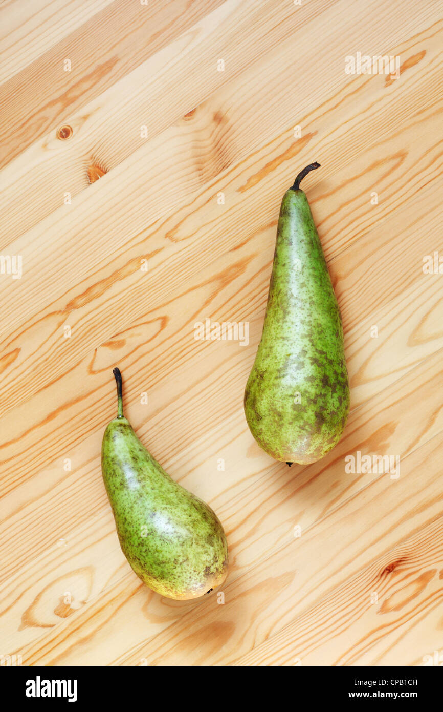 Two pears lying on a wooden surface Stock Photo - Alamy