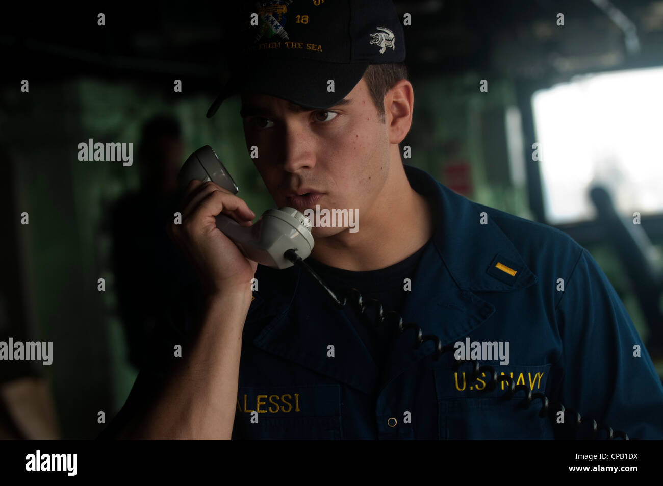 Ensign Thomas Alessi relays information through a sound powered ...