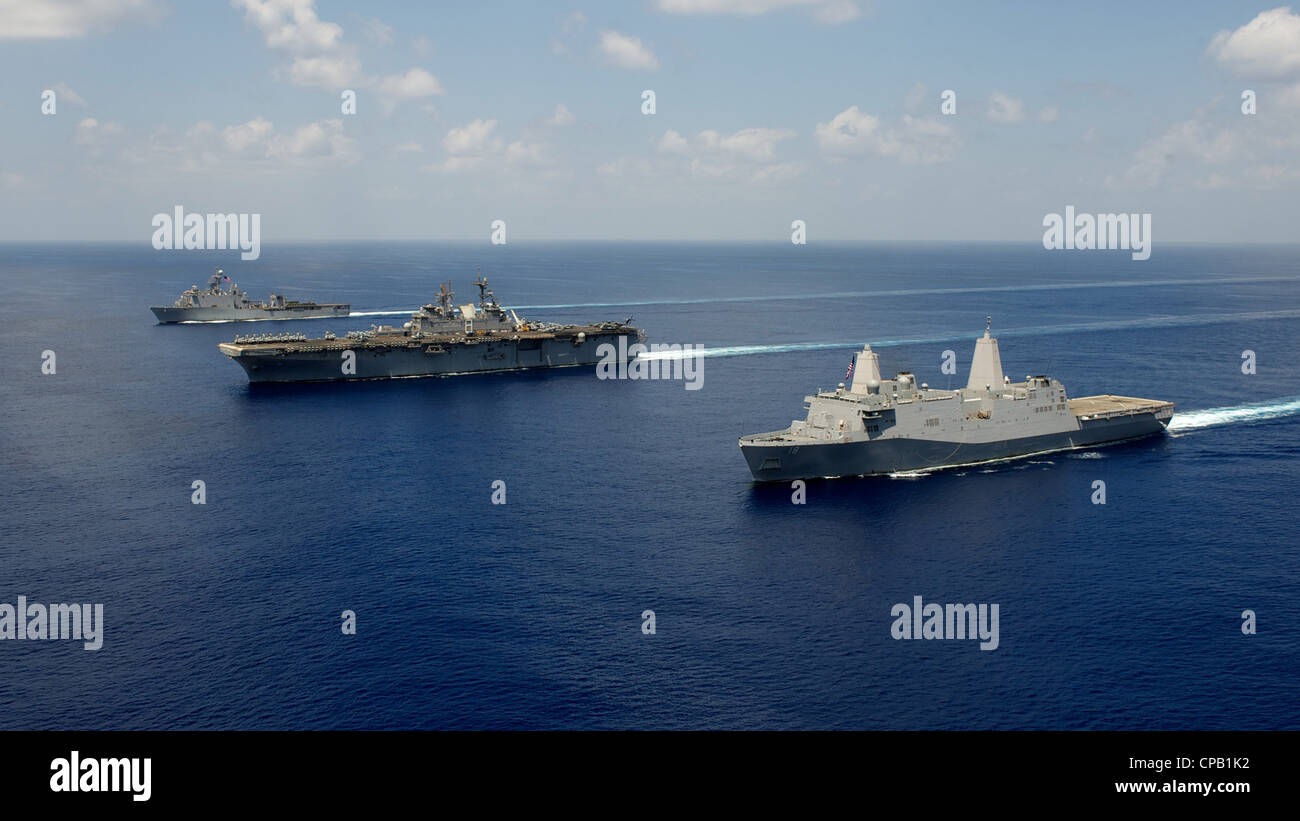 The amphibious dock landing ship USS Pearl Harbor (LSD 52), left, the ...