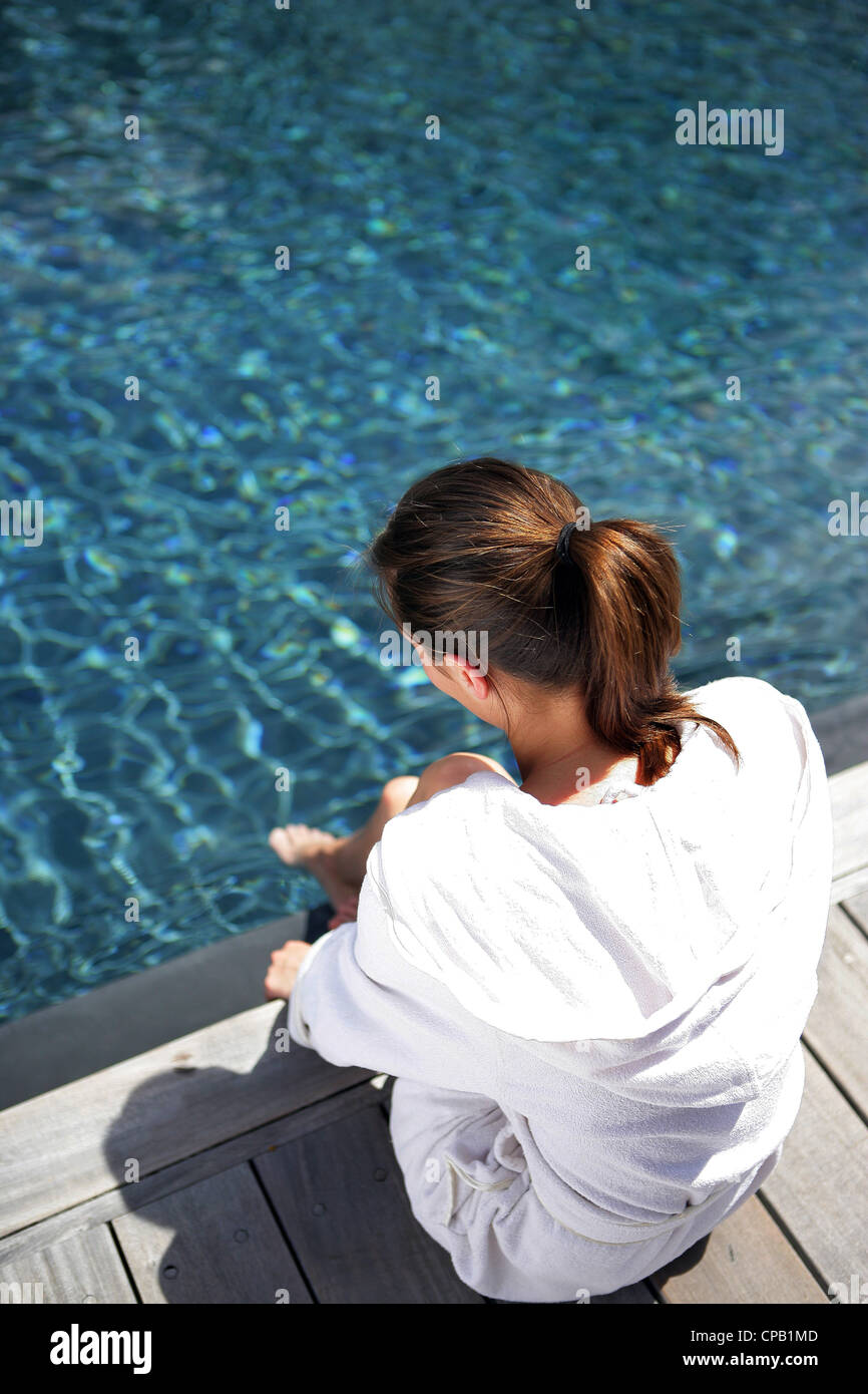 Woman sitting by a pool Stock Photo - Alamy