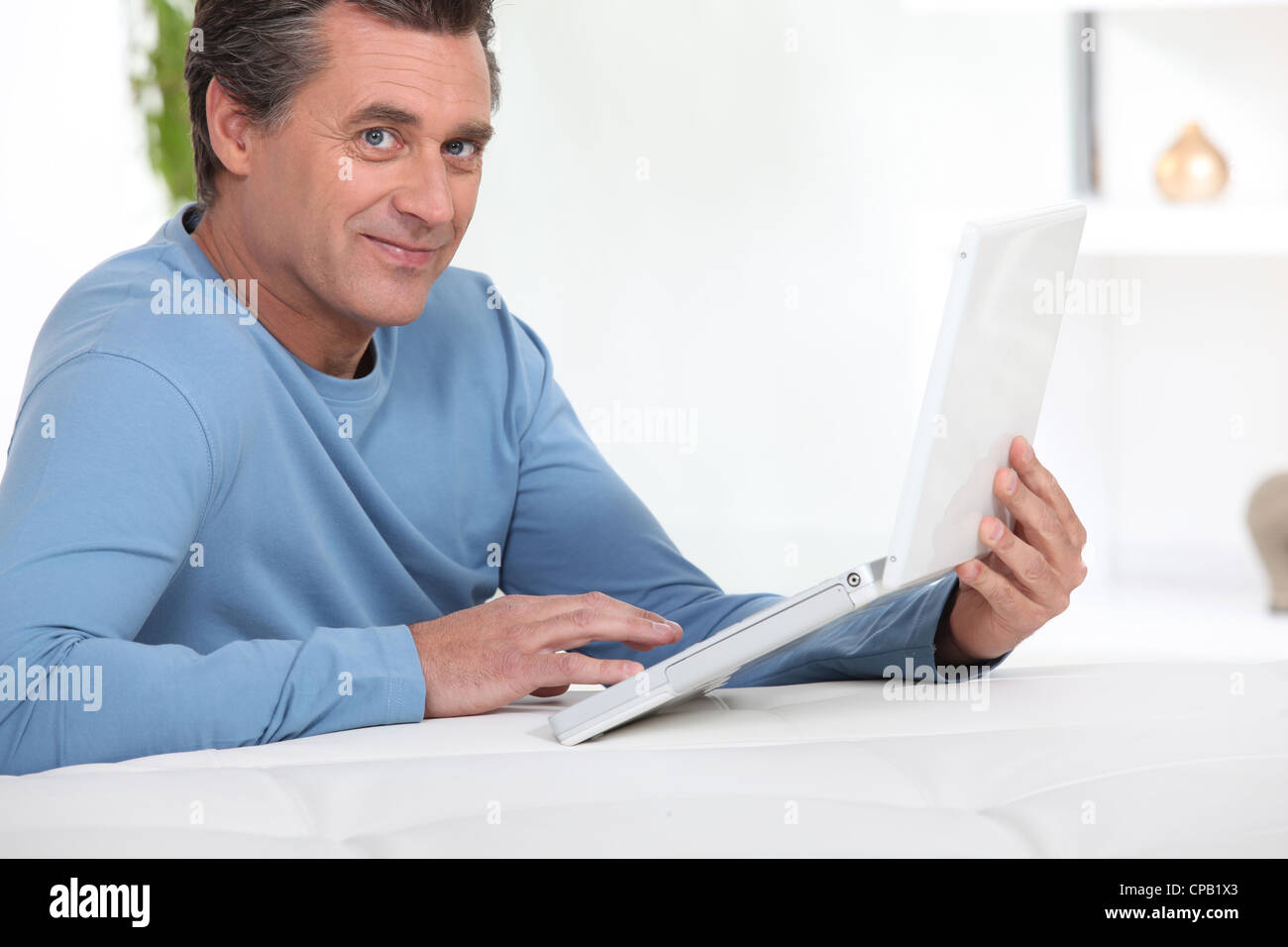 Man with computer inclined Stock Photo - Alamy