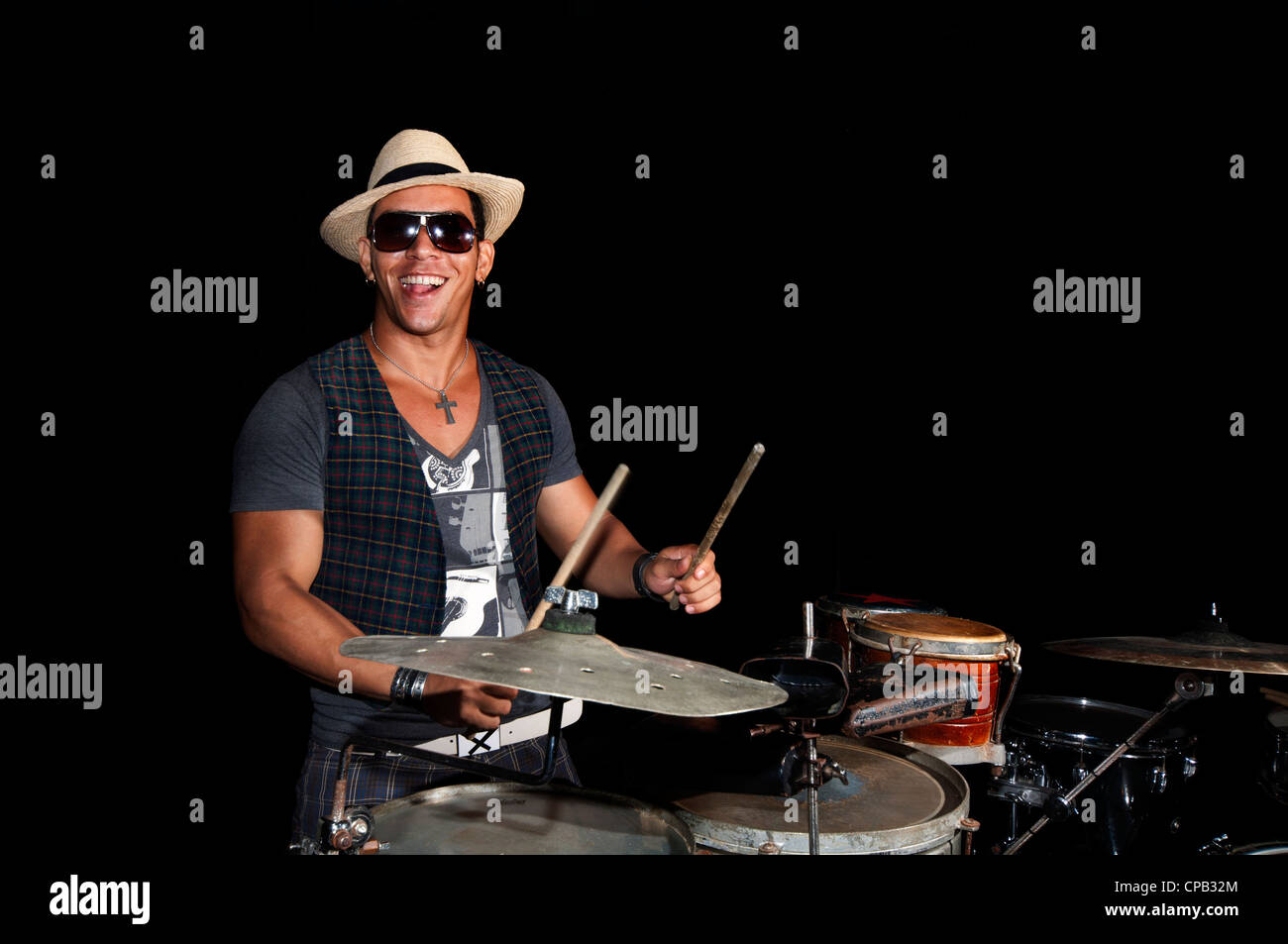 Portrait of young cuban percussionist isolated over black background ...