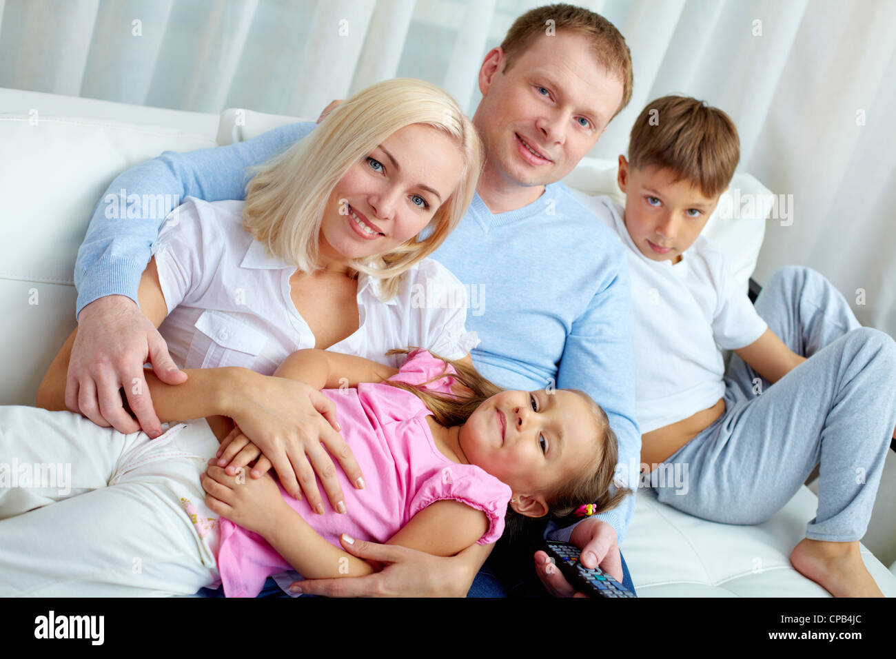 Portrait of happy family with two children sitting at home Stock Photo ...