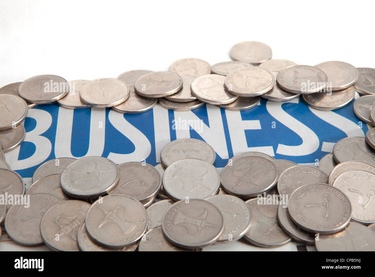 Coins on the business newspaper Stock Photo - Alamy