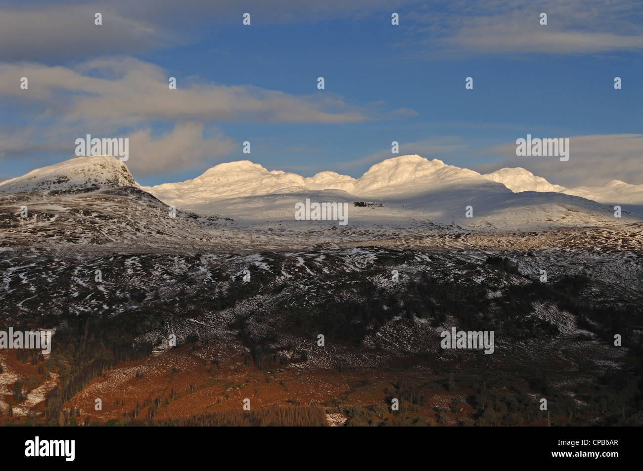 The snow-covered Tarmachan Hills in dappled light under a blue winter ...