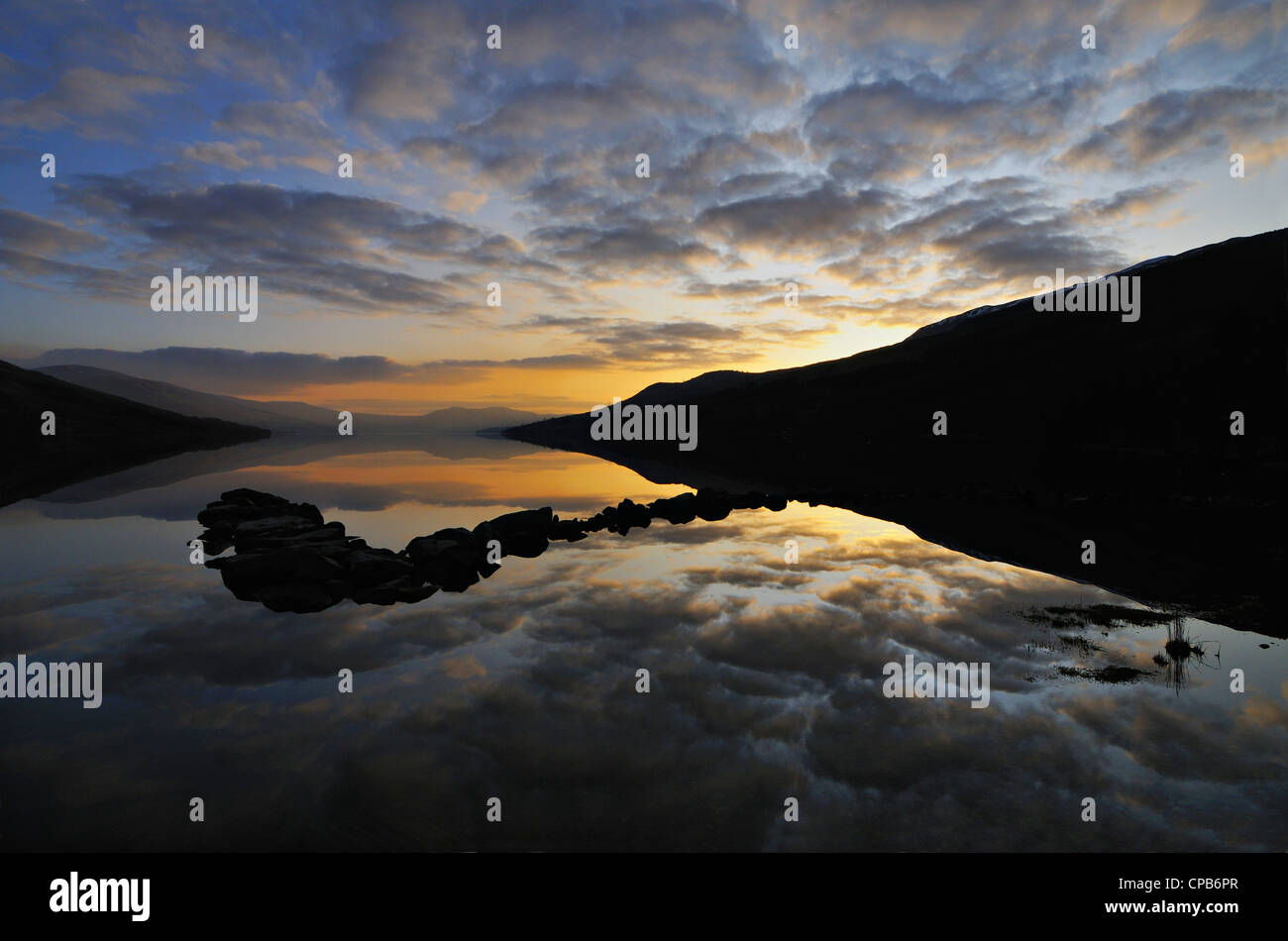 A sunset sky reflected in the still waters of Loch Tay, Perthshire ...