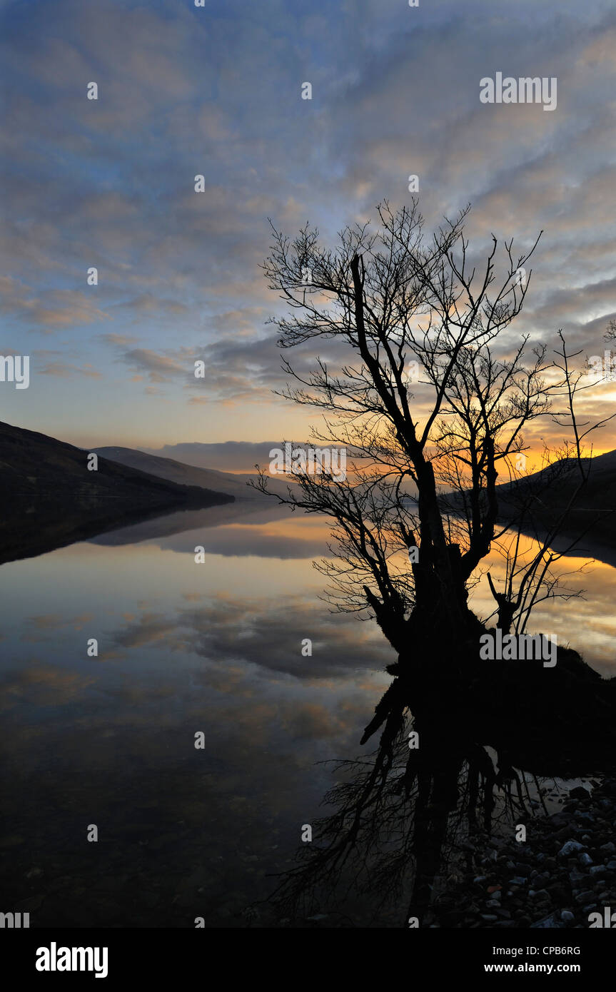 A sunset sky reflected in the still waters of Loch Tay, Perthshire ...