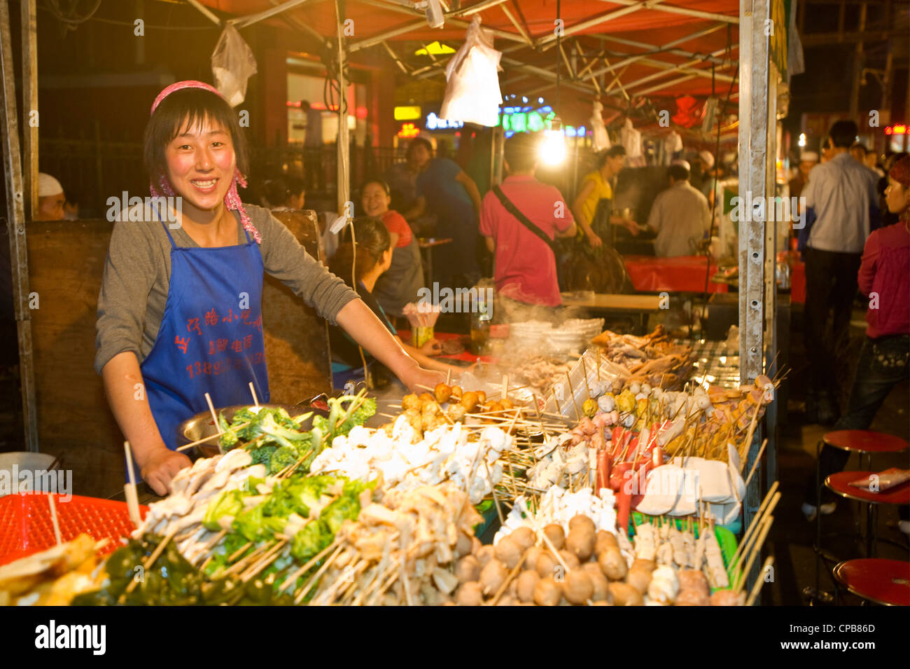 A smiling Chinese lady selling snack food at the well known Zhengning ...