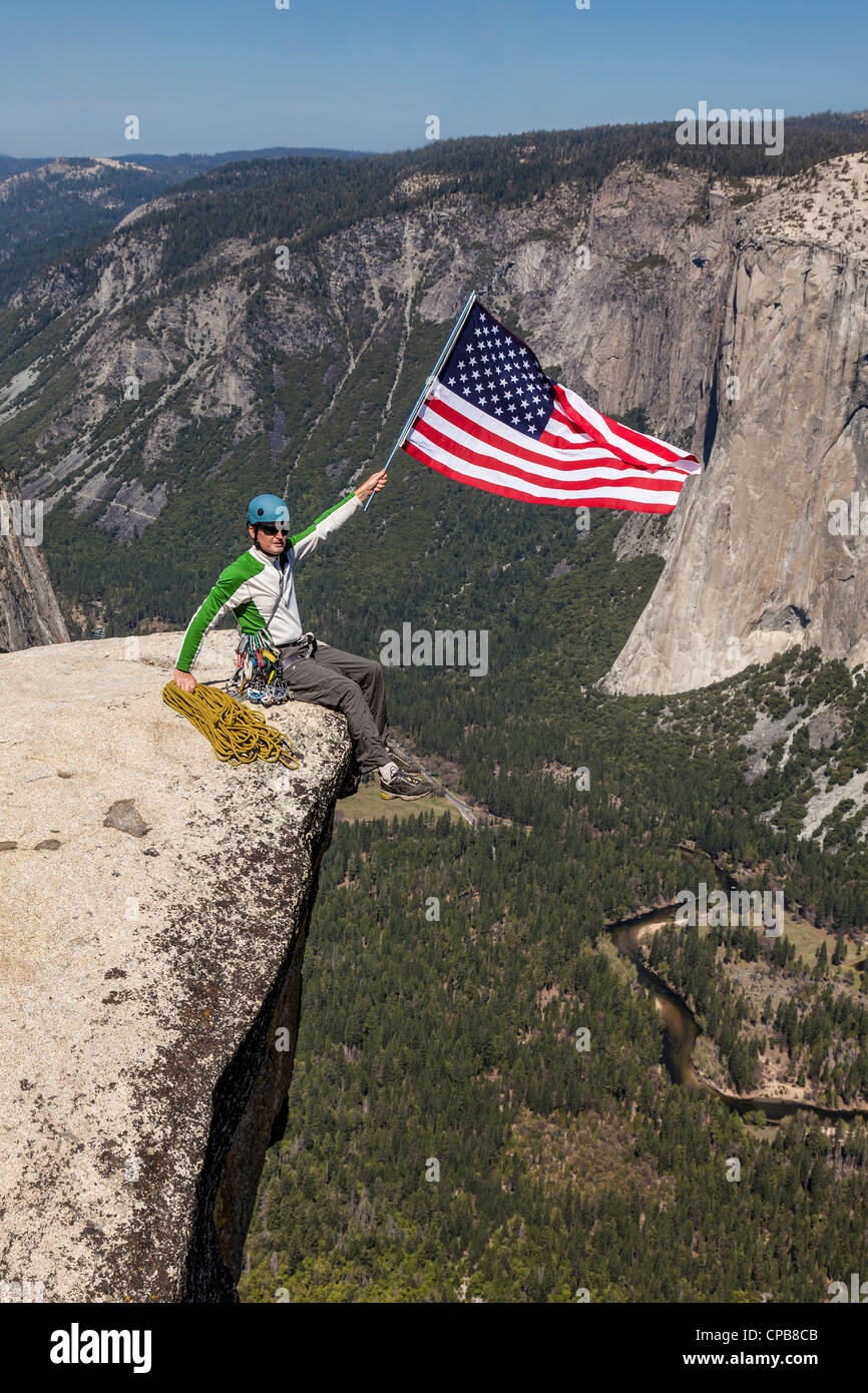 Climber on the summit waving an American flag Stock Photo - Alamy