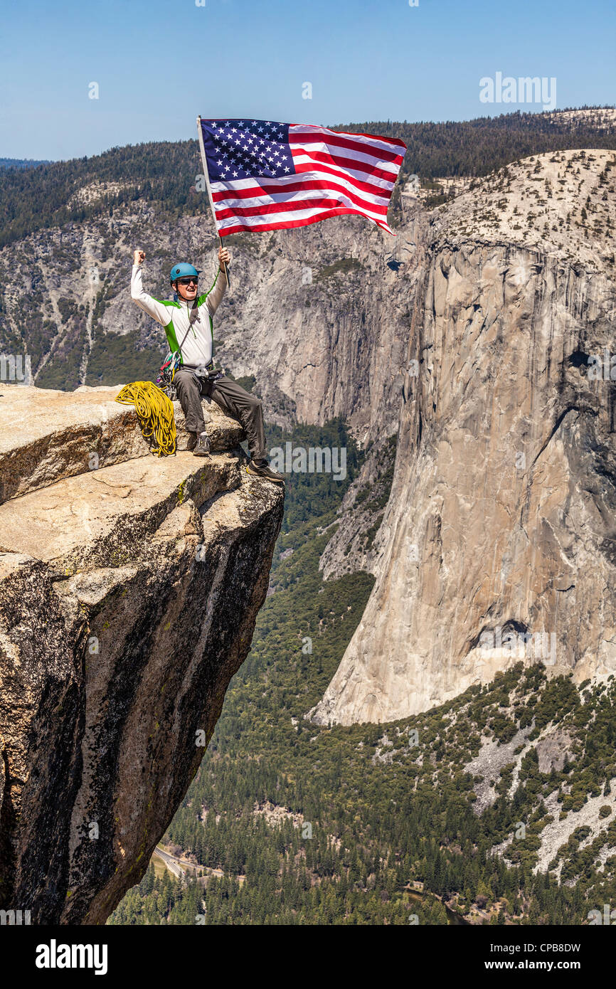 Climber on the summit waving an American flag Stock Photo - Alamy