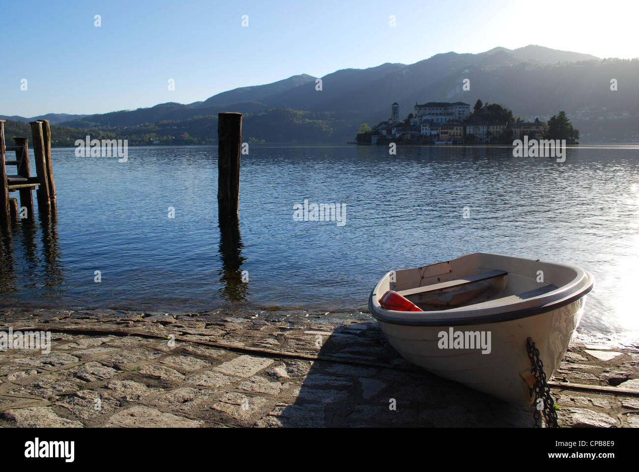 Boat on the dock at Orta lake, St. Giulio island in background ...