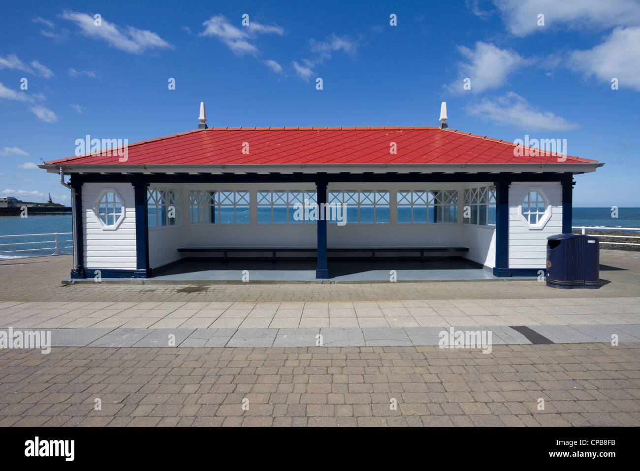 Edwardian promenade shelter with red roof. sea and sky in background ...