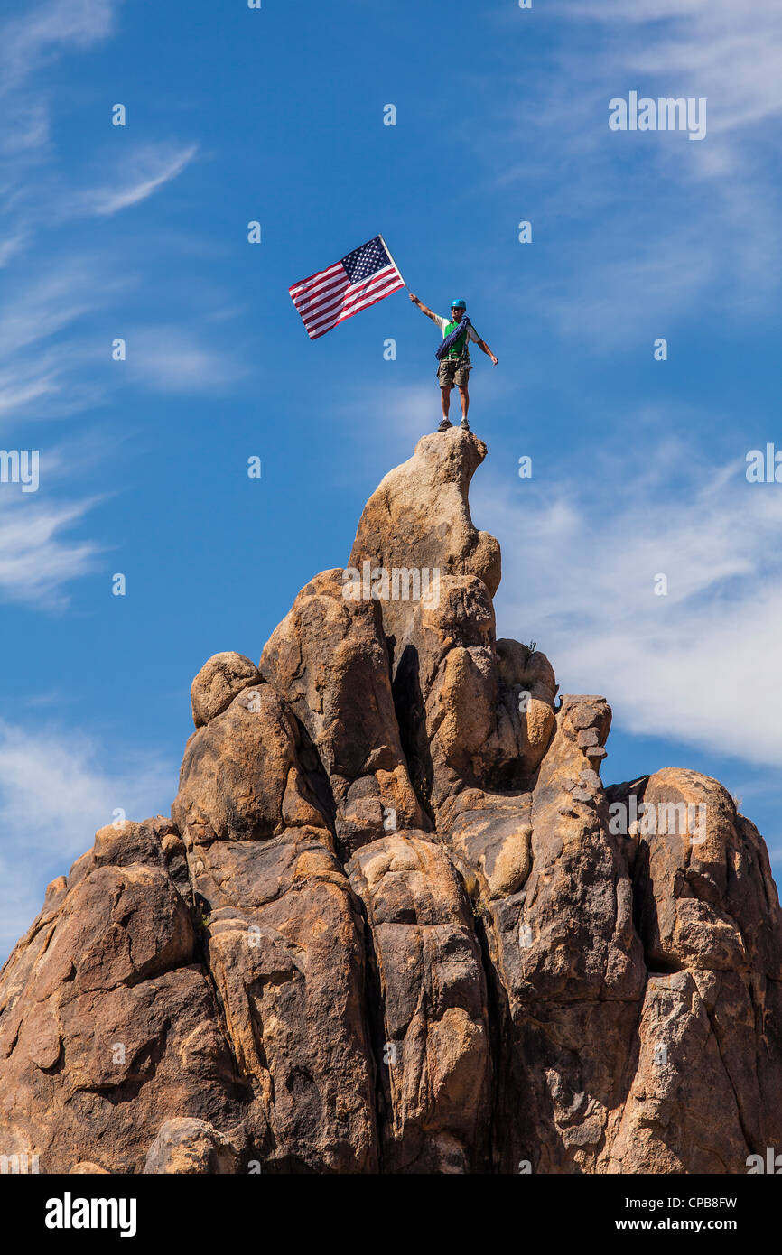 Climber on the summit waving an American flag Stock Photo - Alamy