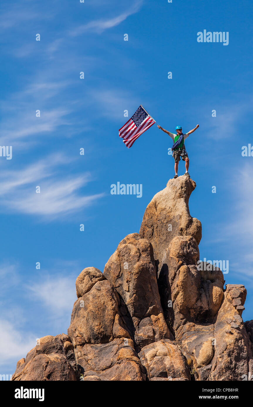 Climber on the summit waving an American flag Stock Photo - Alamy