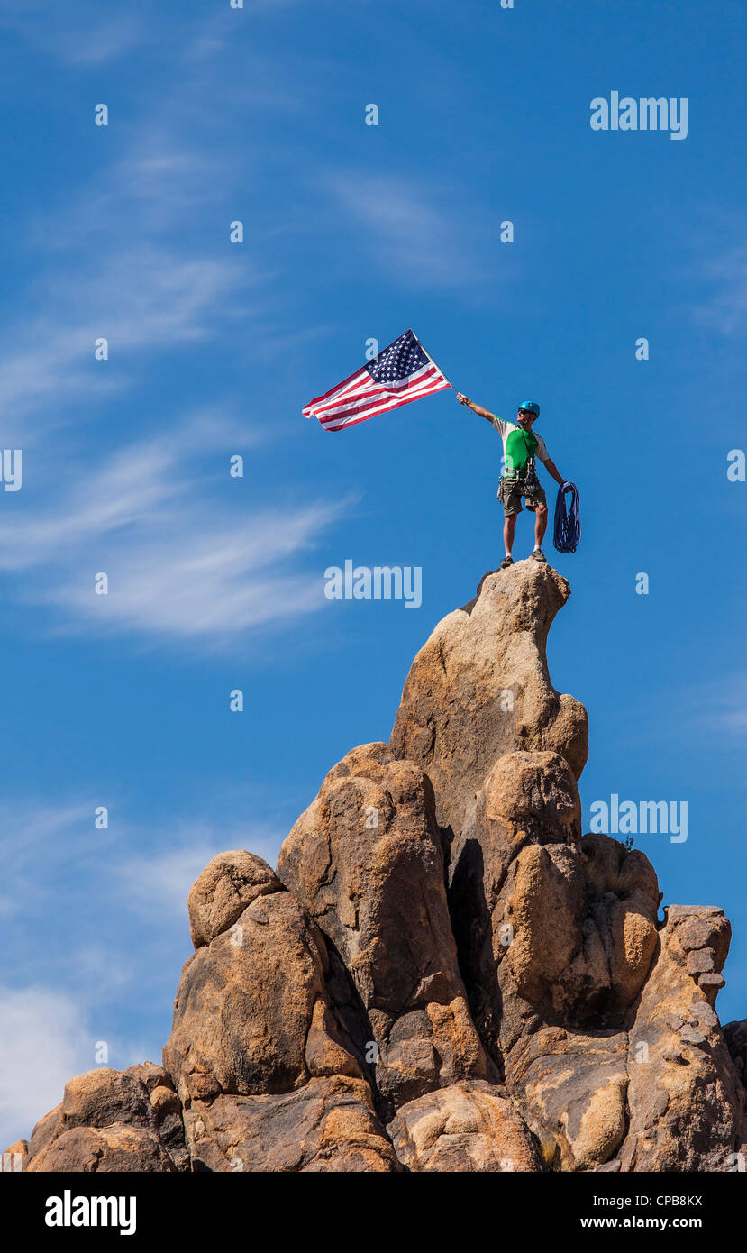 Climber on the summit waving an American flag Stock Photo - Alamy