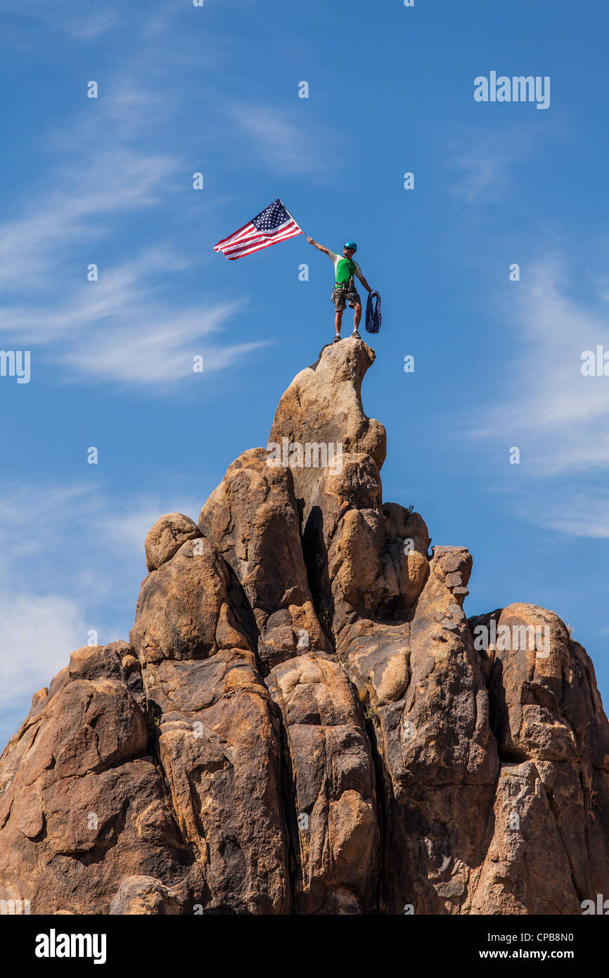 Climber on the summit waving an American flag Stock Photo - Alamy
