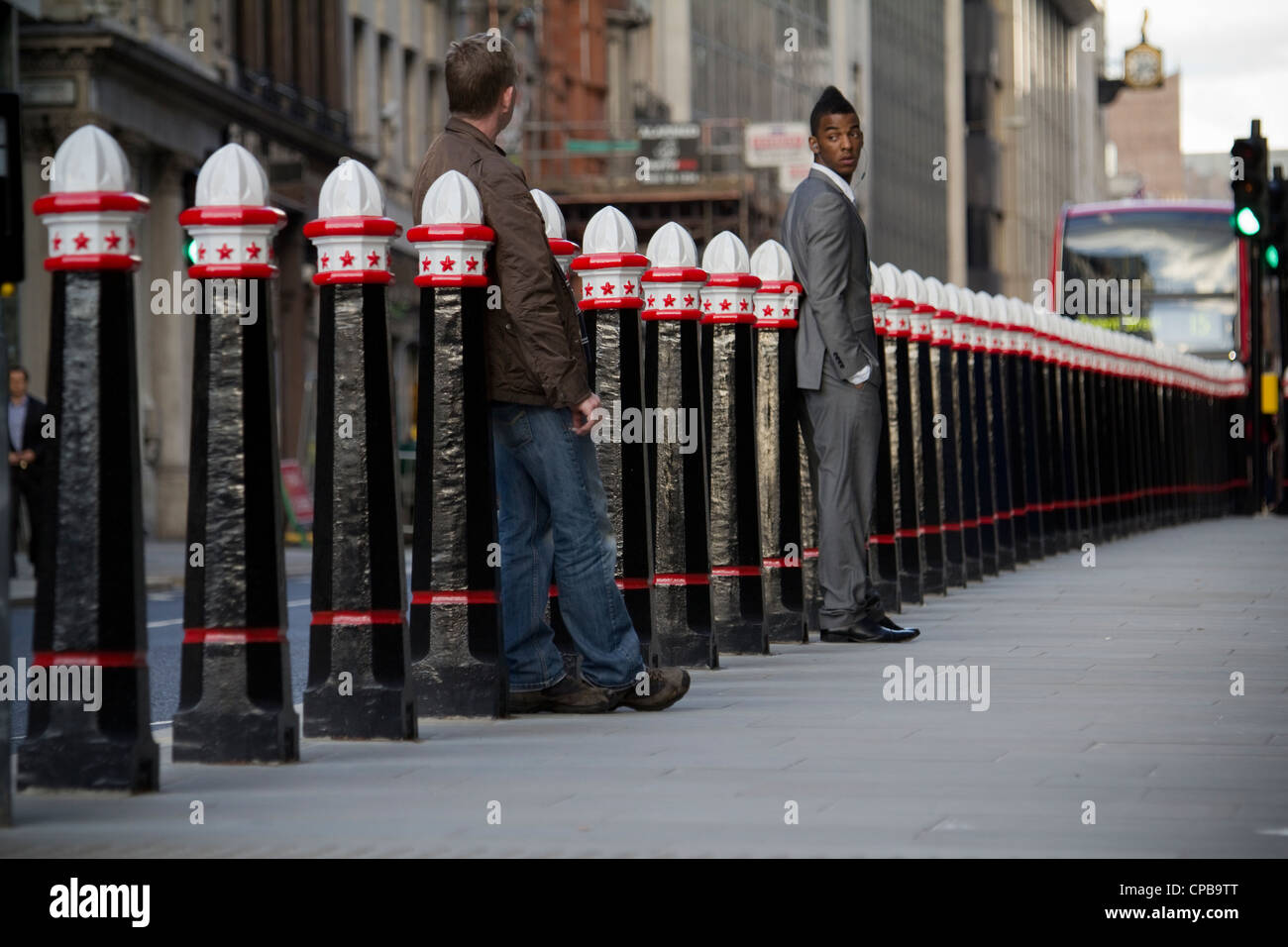 Men waiting by, Freshly painted City of London Bollards outside Cannon ...