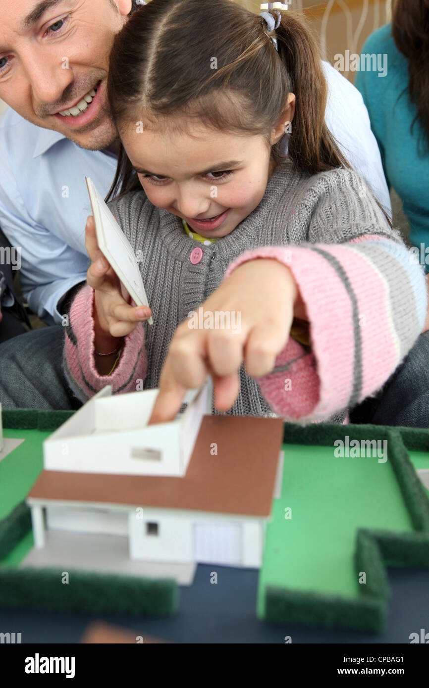 Family sat with model of new house Stock Photo - Alamy