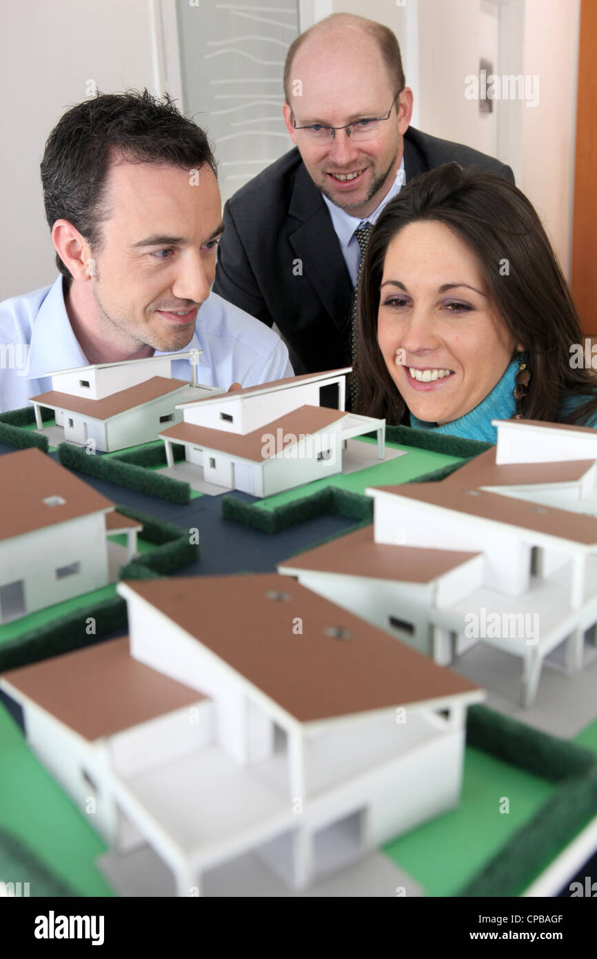 Architect showing model housing to customers Stock Photo - Alamy