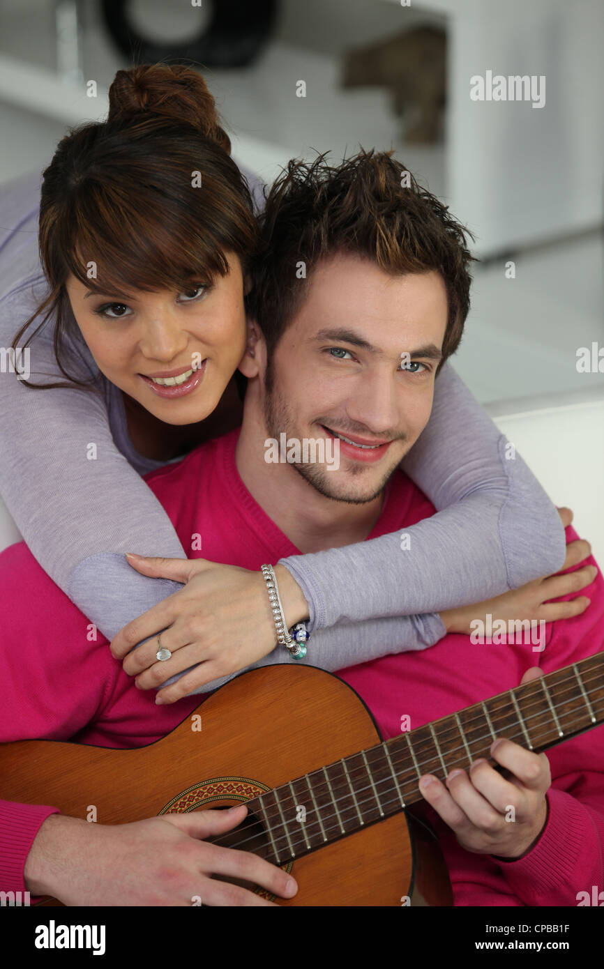 Boyfriend playing the guitar Stock Photo - Alamy