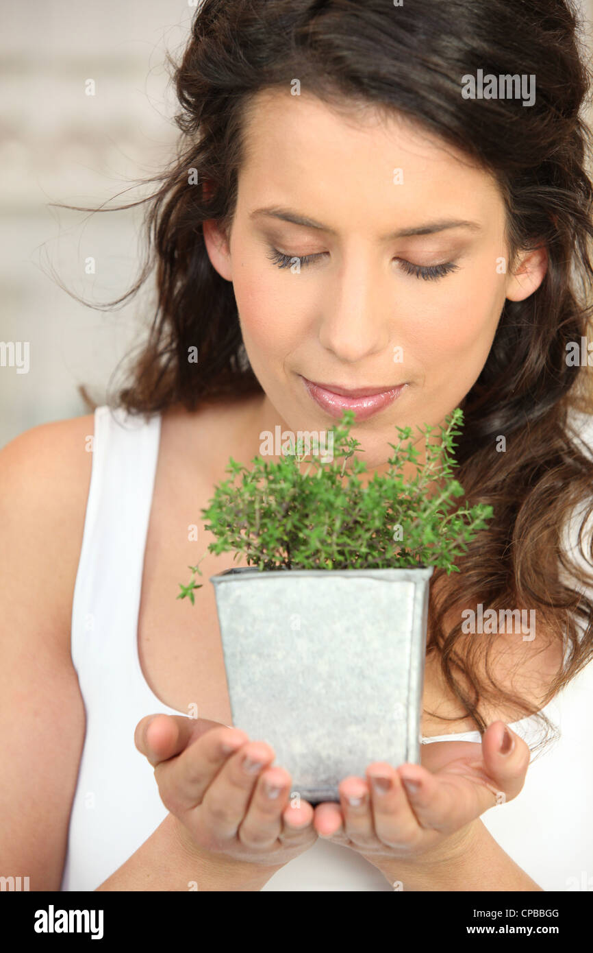 Woman smelling a herb pot Stock Photo - Alamy