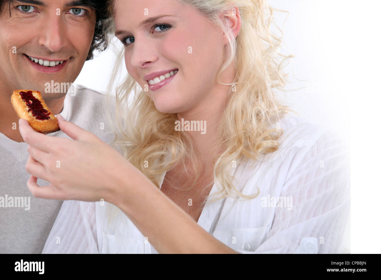 Woman giving man a piece of cake Stock Photo - Alamy