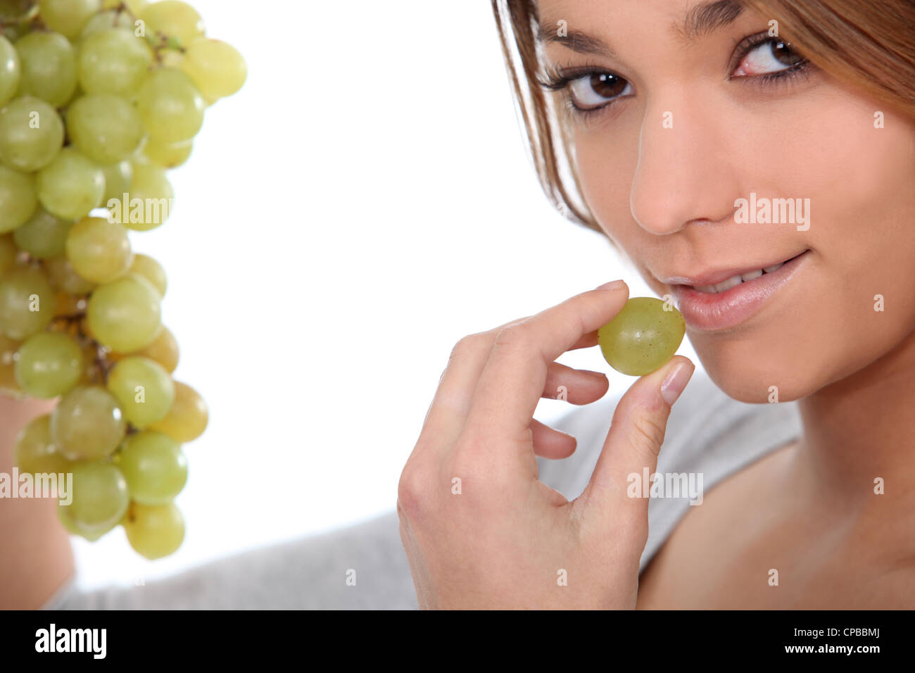 Woman eating green grapes Stock Photo - Alamy