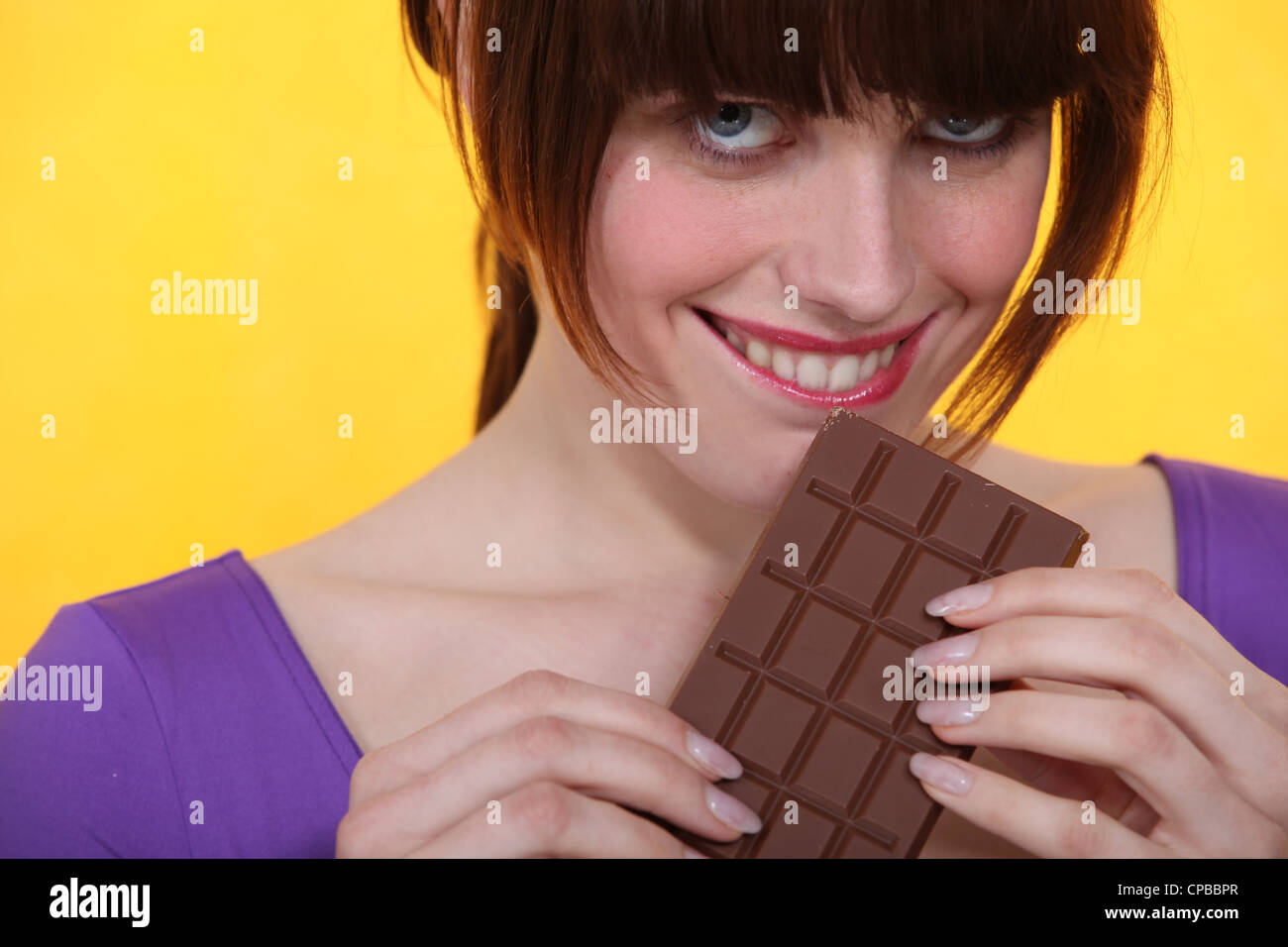 Young woman biting chocolate hi-res stock photography and images - Alamy