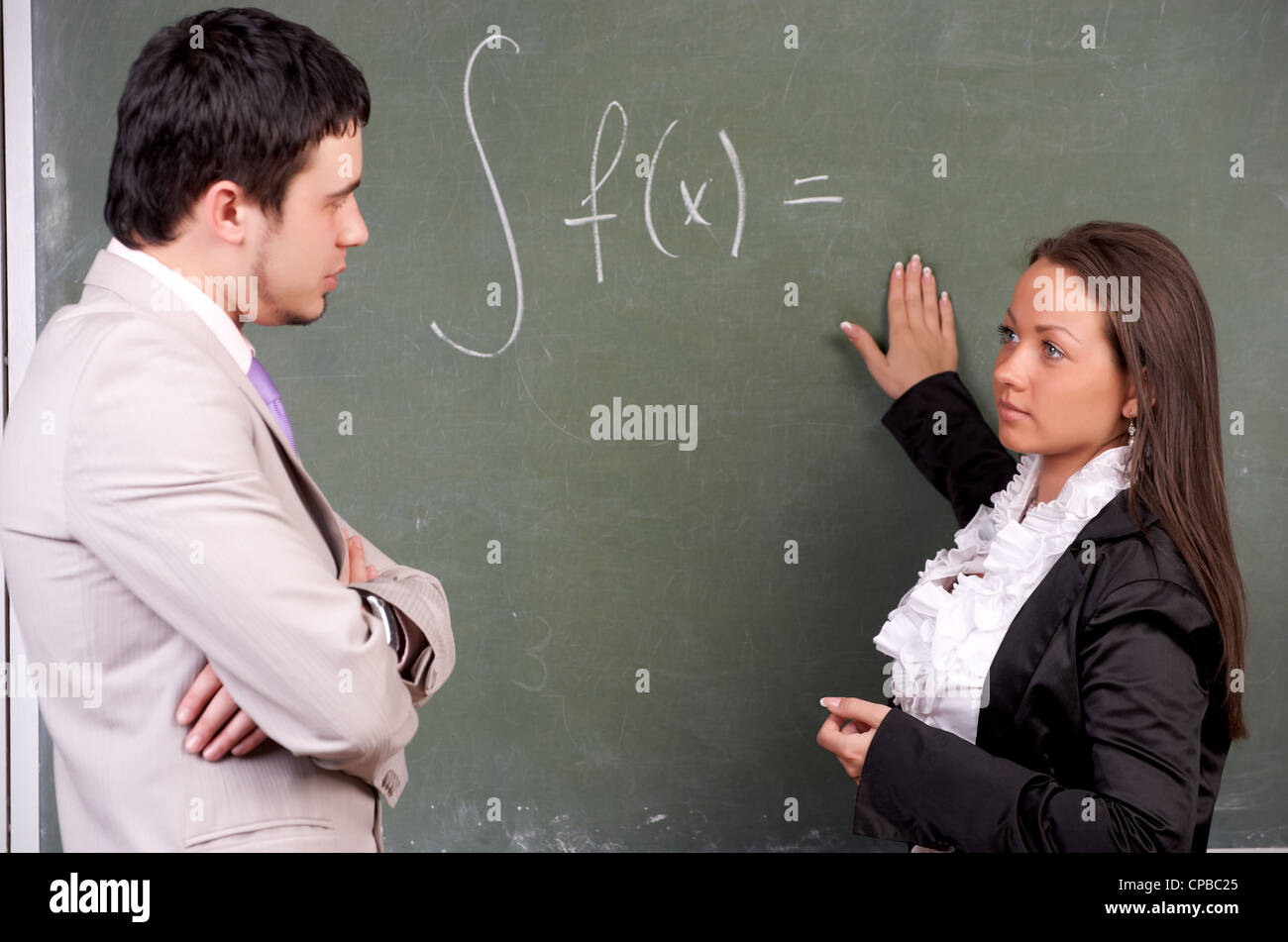 Young teacher and student doing exercise on blackboard Stock Photo - Alamy