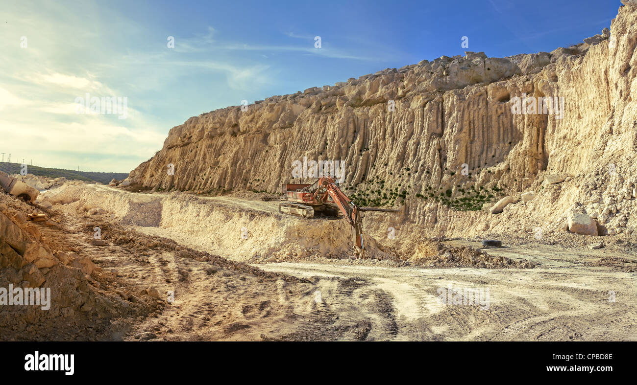 A single backhoe in a large quarry Stock Photo - Alamy