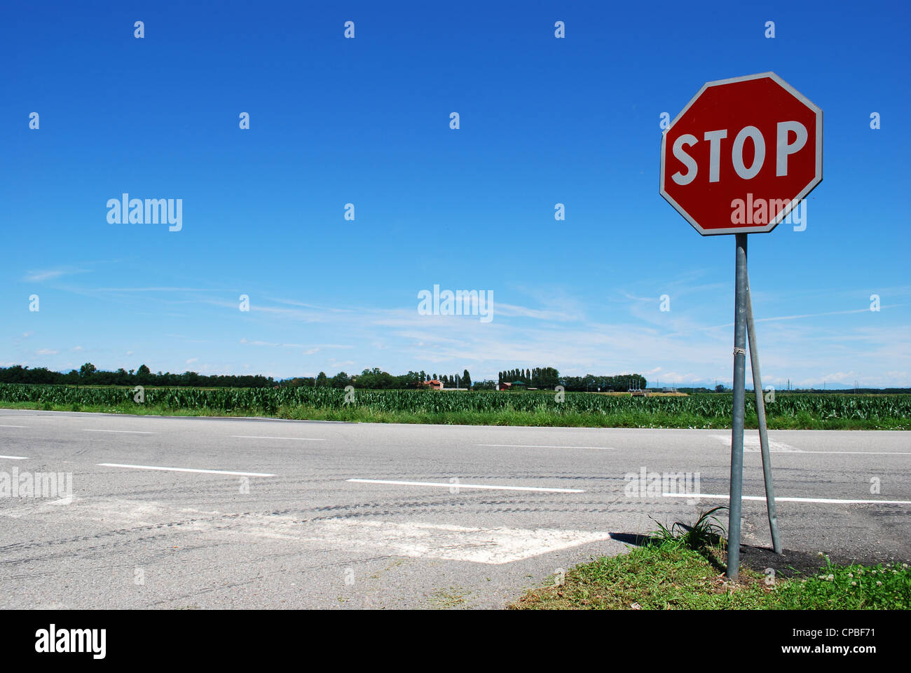 Stop sign in a country road on blue sky Stock Photo - Alamy