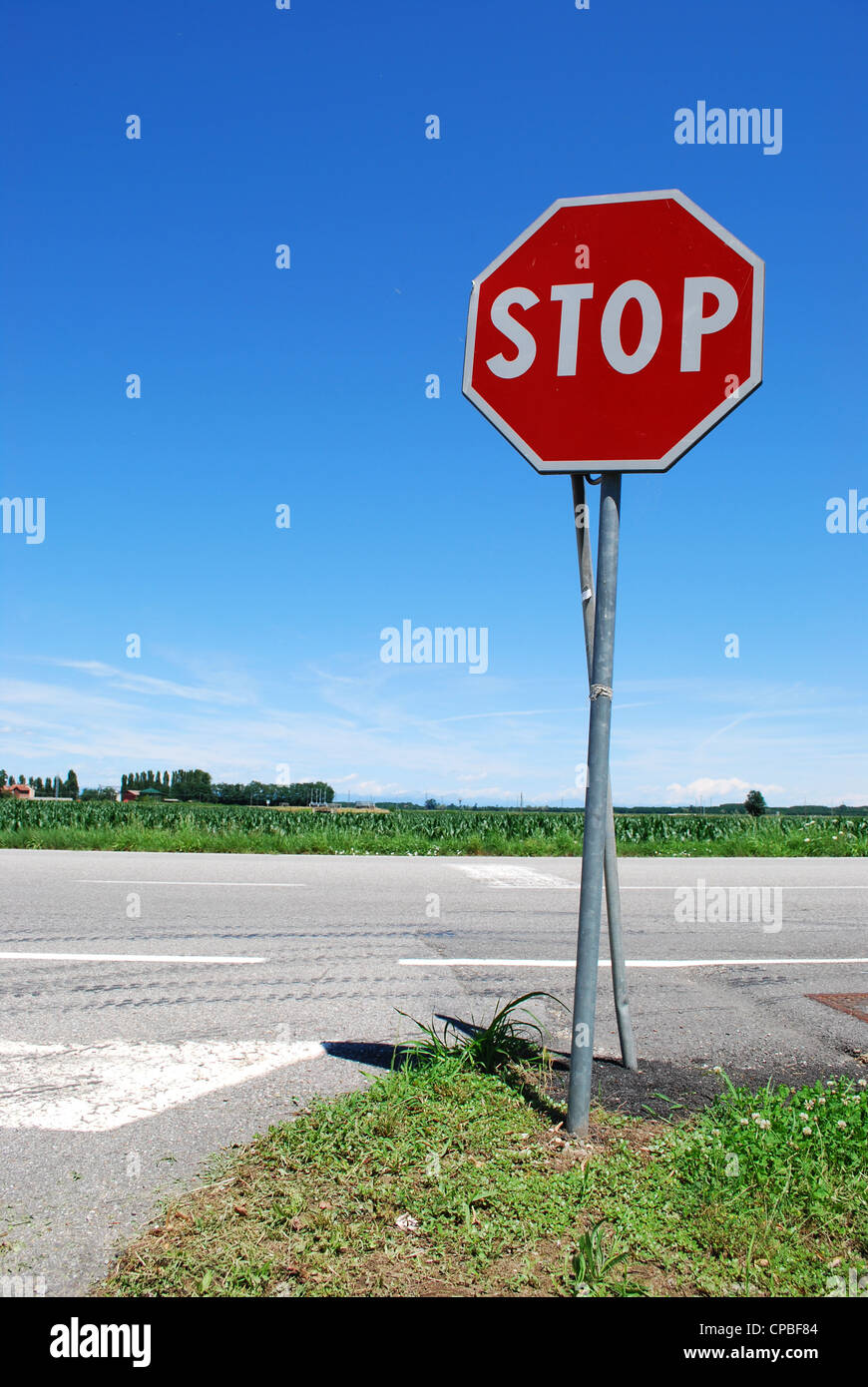 Stop sign in a country road on blue sky Stock Photo - Alamy
