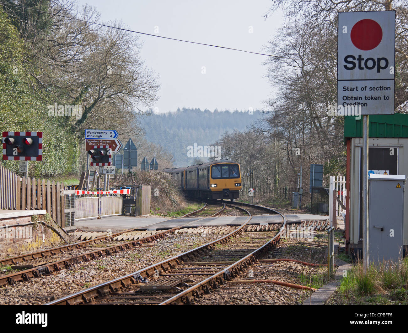 Train approaching an unmanned level crossing outside Eggesford station ...