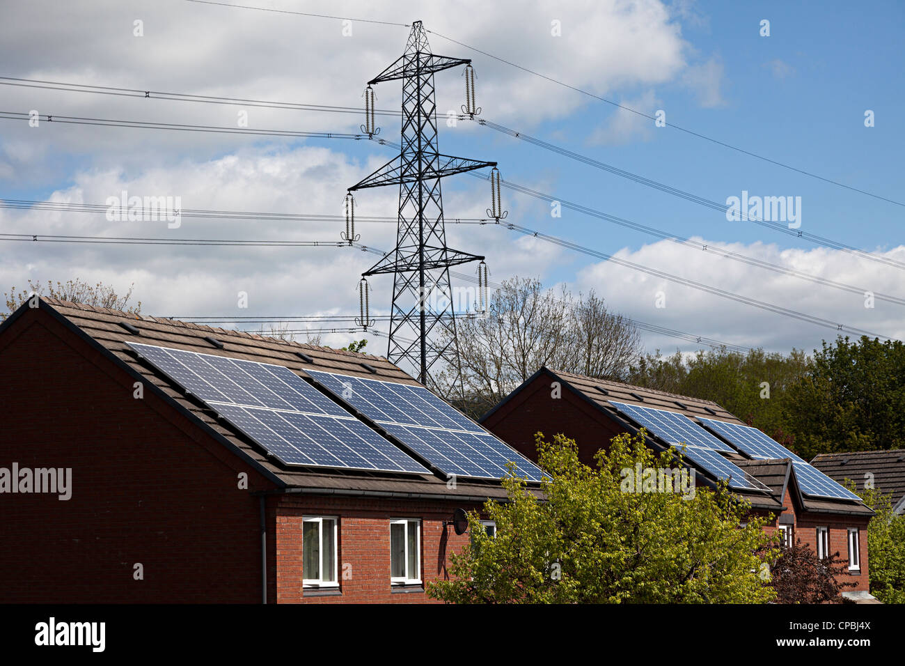 Solar panels on houses with electricity pylons behind, Wales, UK Stock ...