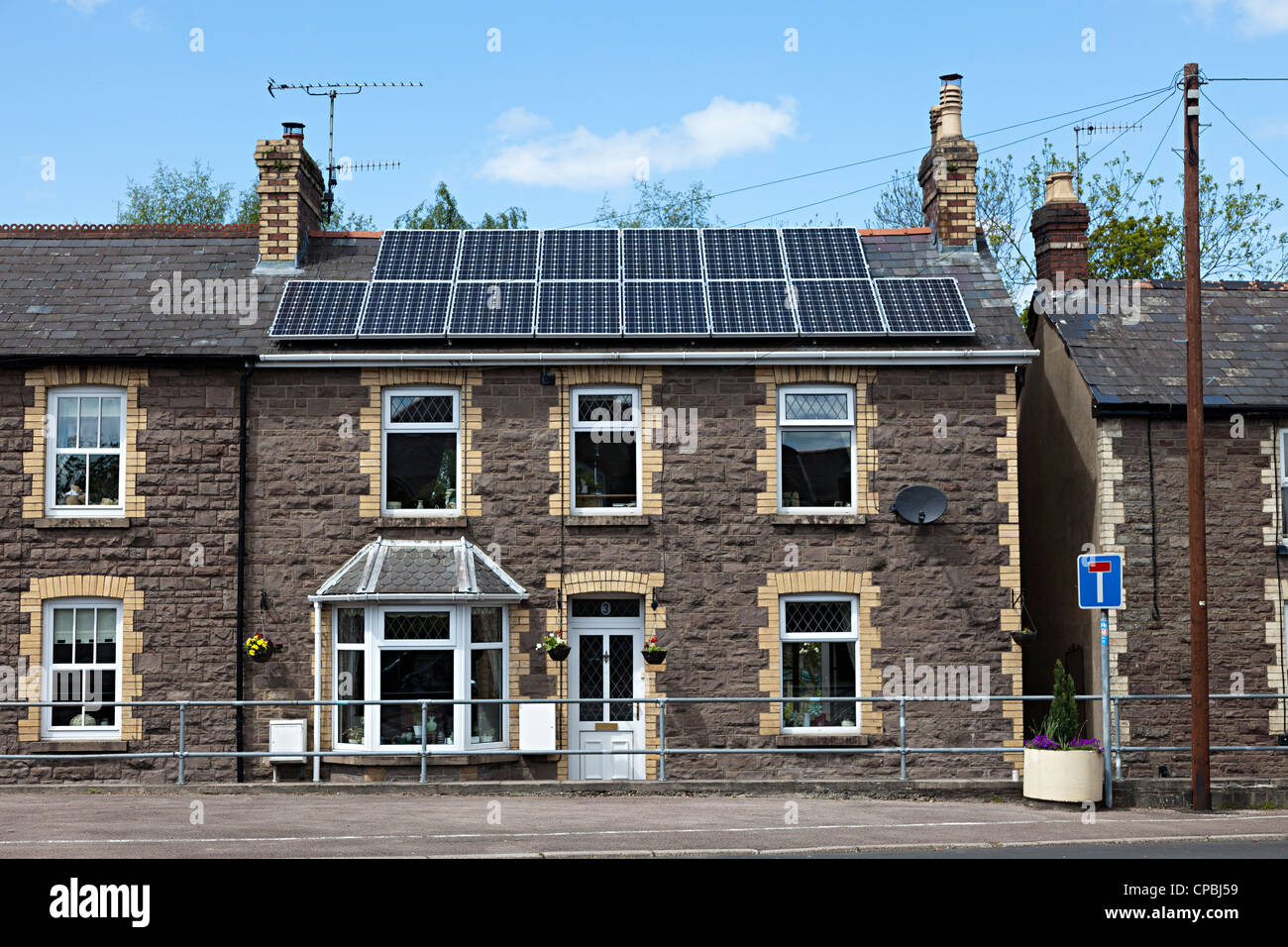 Old stone house in terrace with modern solar panels on roof, Llanfoist ...