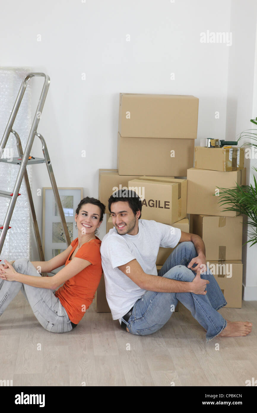 Couple sat next to boxes Stock Photo - Alamy