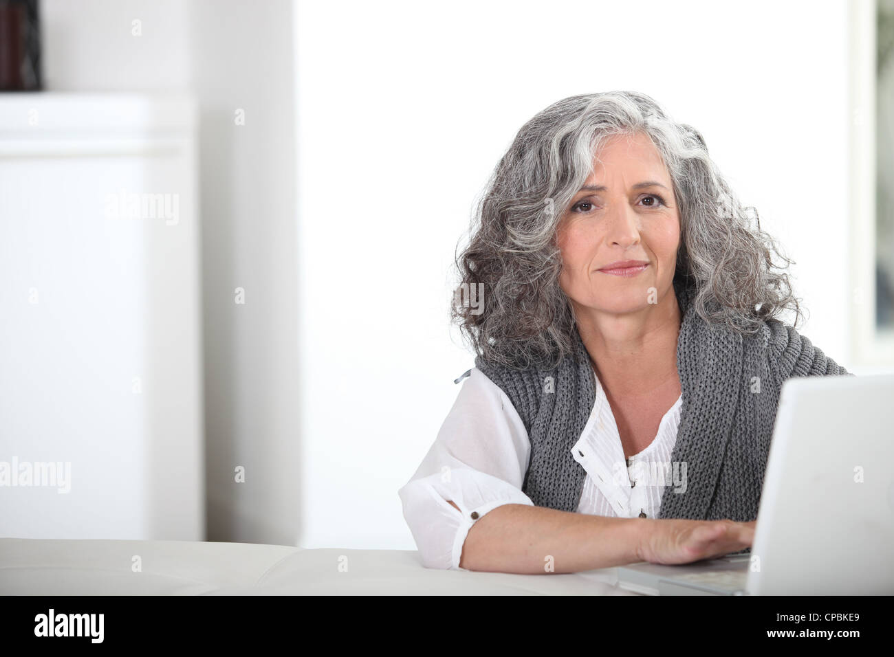 Woman with gray hair and computer Stock Photo - Alamy