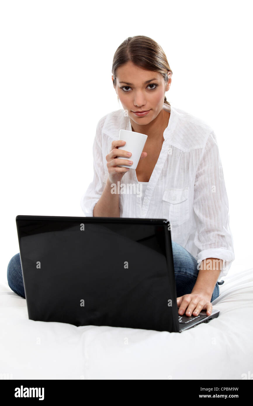 Girl drinking a tea in front of laptop Stock Photo - Alamy