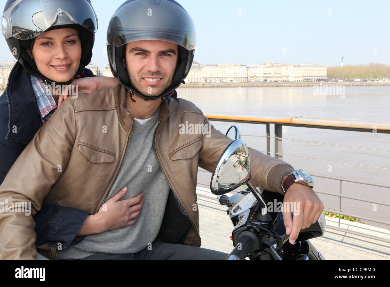 Young couple on a moped by a river Stock Photo - Alamy