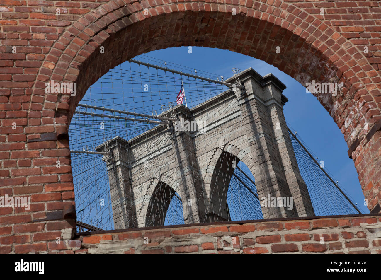 Detail of the Brooklyn Bridge viewed through a brick archway in ...
