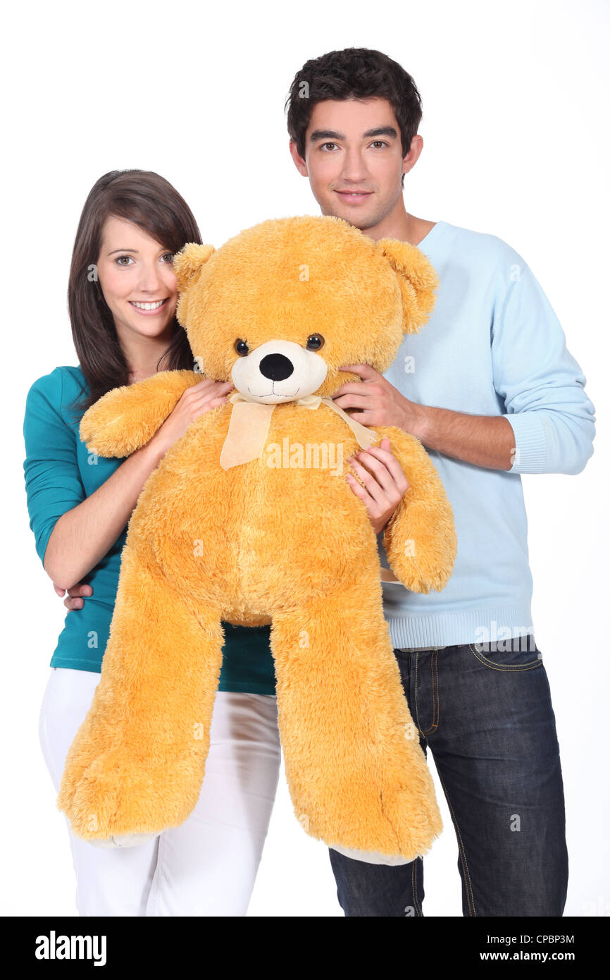 Young couple holding big toy bear Stock Photo - Alamy