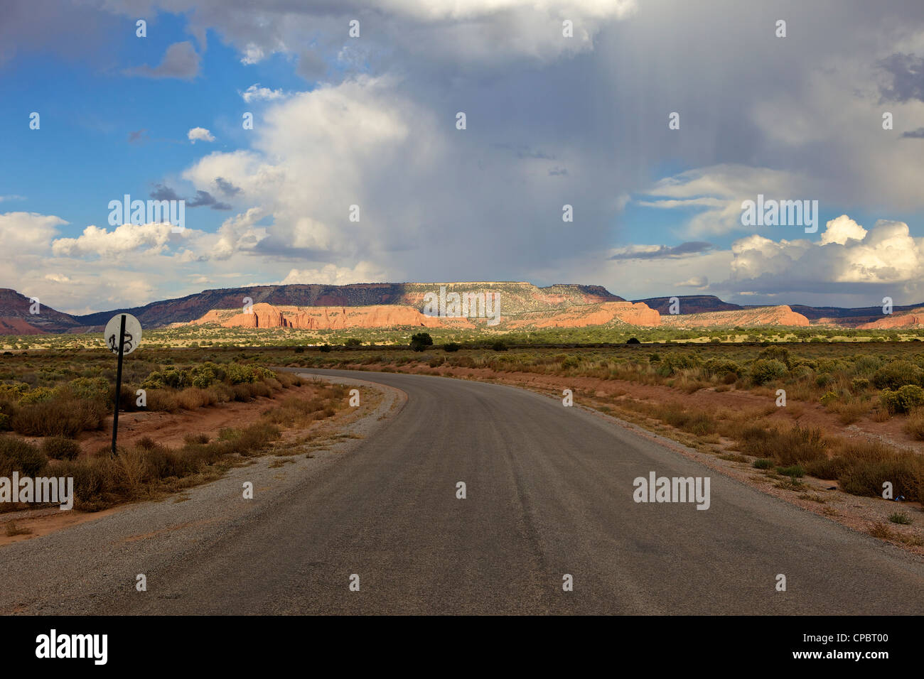 Road and green fields and red Rock landscape, New Mexico Stock Photo ...