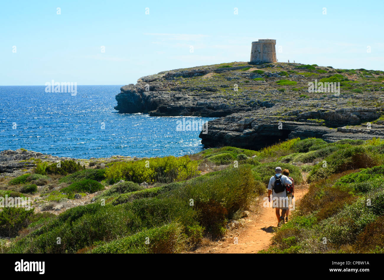 Wakers on the Cami de Cavalls coastal path near the Martello Tower at ...