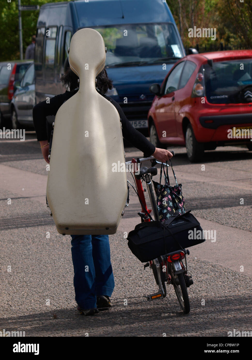 Woman carrying a cello on her back, Cambridge, UK Stock Photo - Alamy